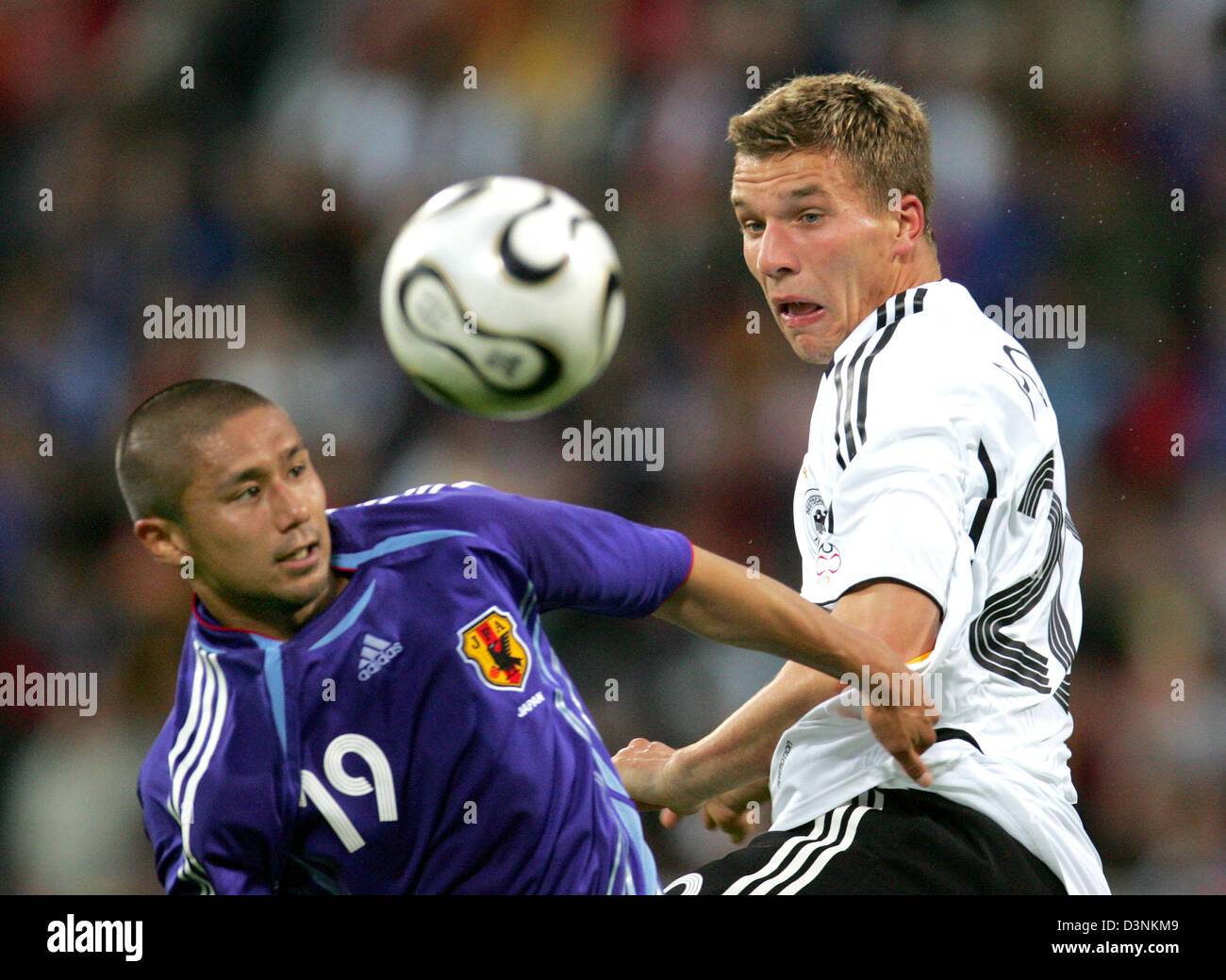 German national soccer player Lukas Podolski (R) fights with Japan's ...