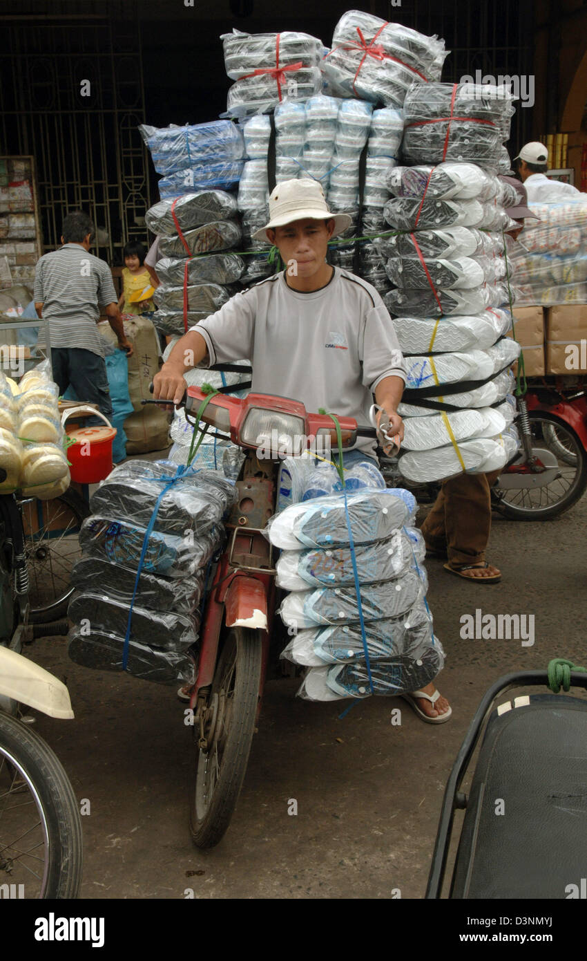A man parks his moped loaded with shows at the Ben Thanh market in Ho ...