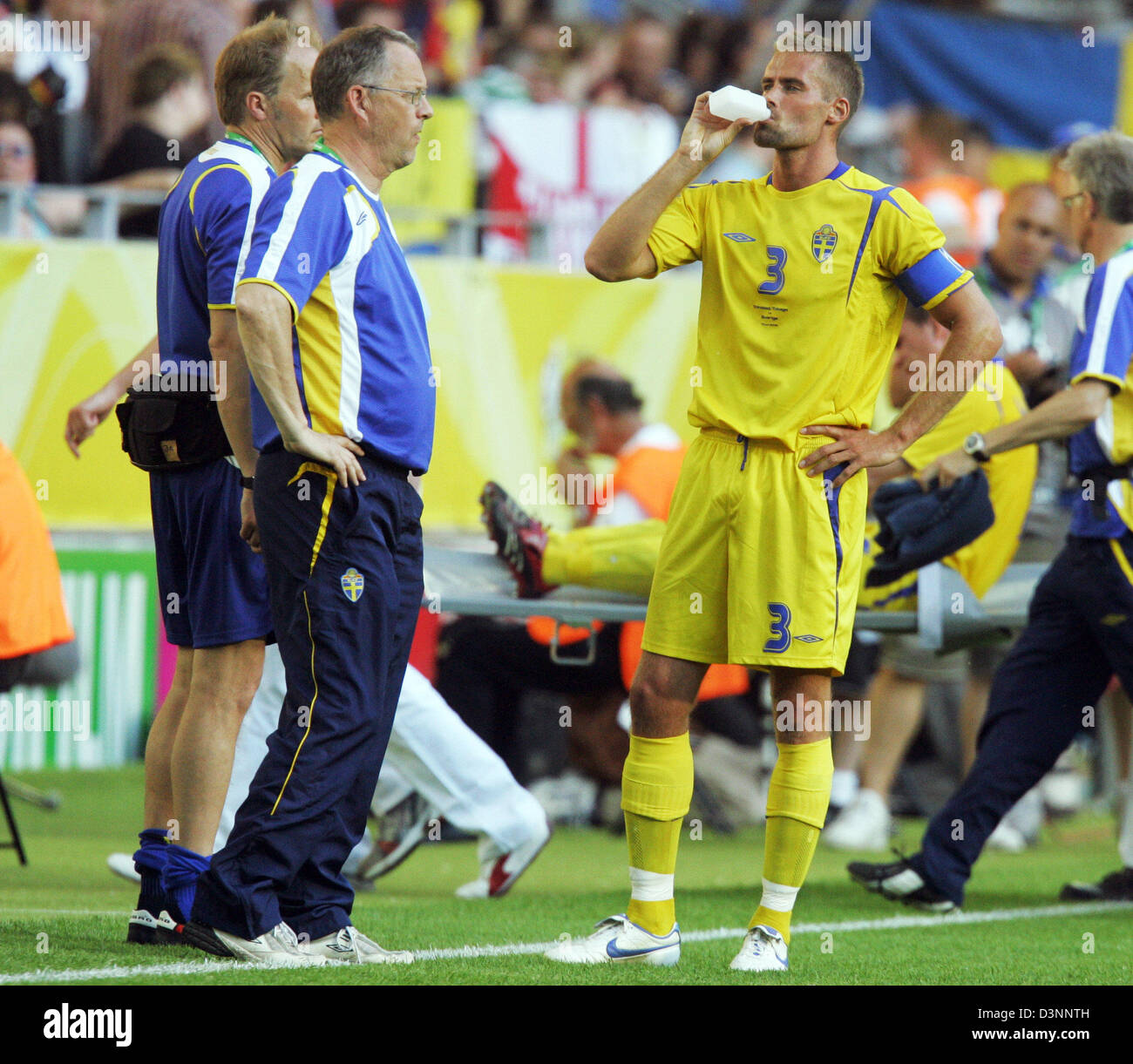 Swedish player Olof Mellberg (R) drinks from a bottle, while his coach ...