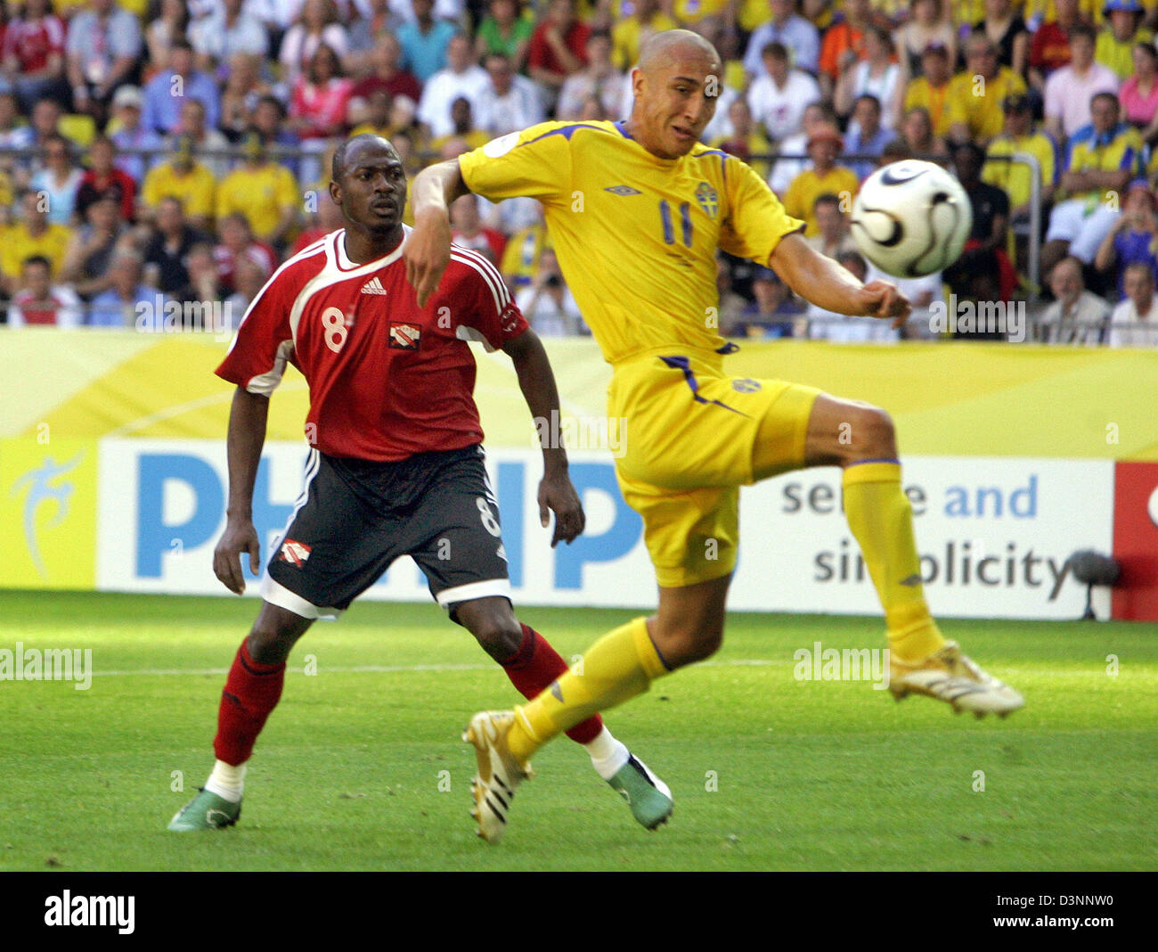 Swedish Henrik Larsson (R) controls the ball, while Cyd Gray from ...