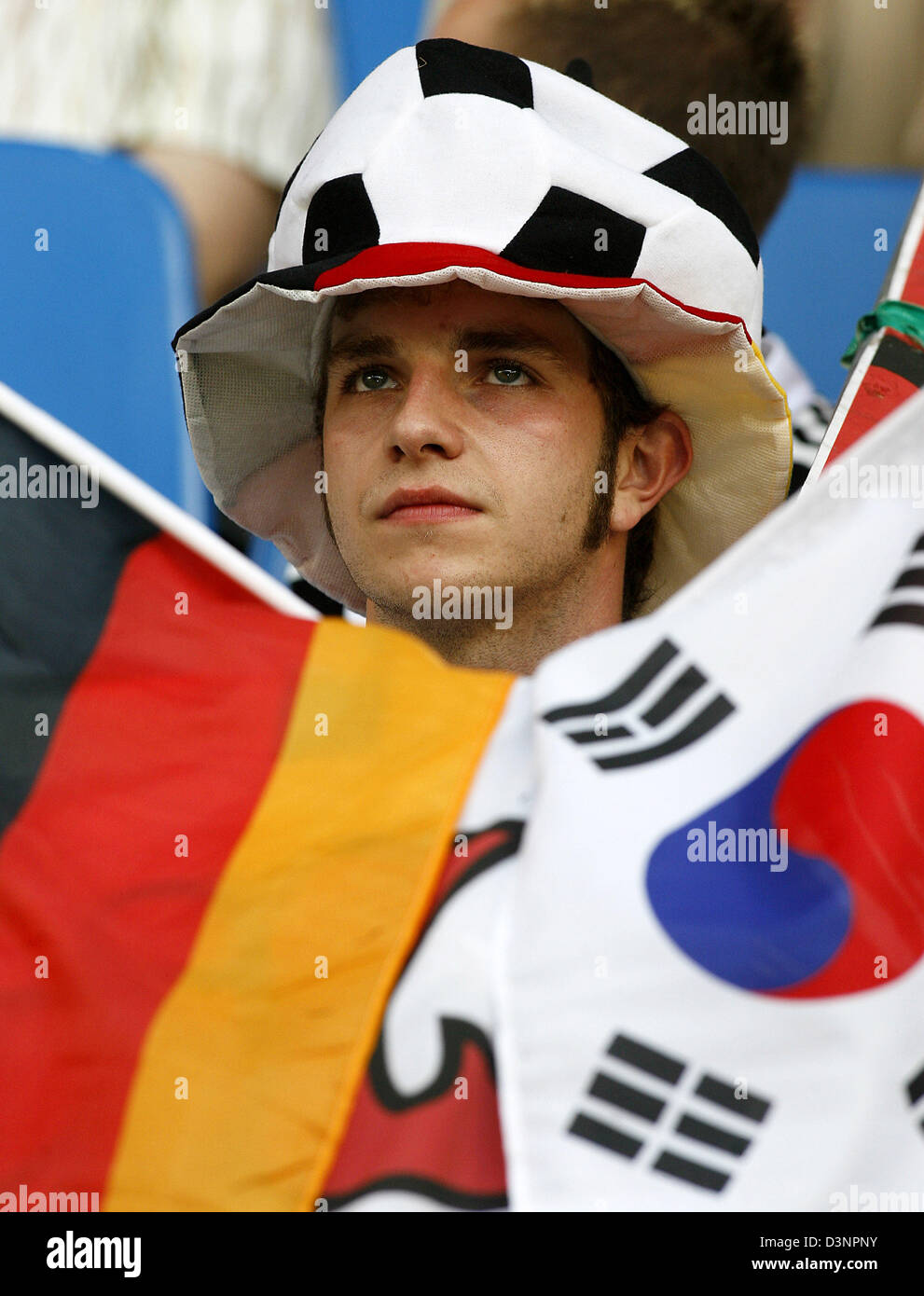 A German soccer fan poses with the national flags of Germany and South ...