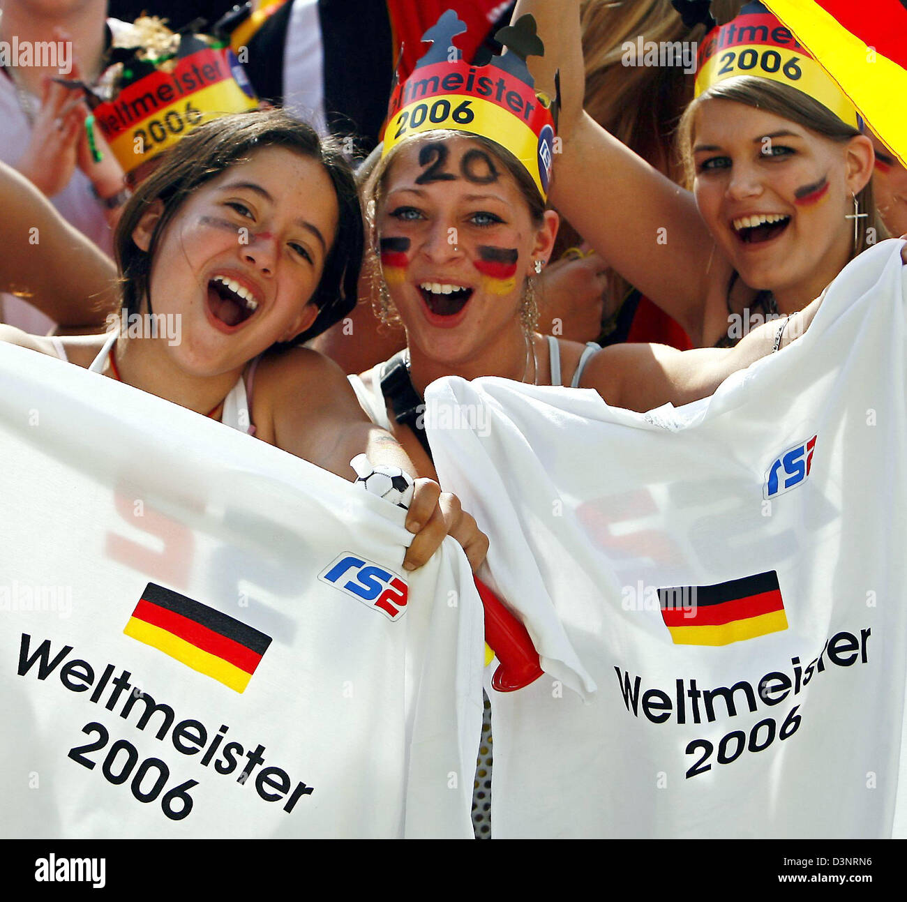 German supporters wear crowns in German colors and wave tee shirts ...