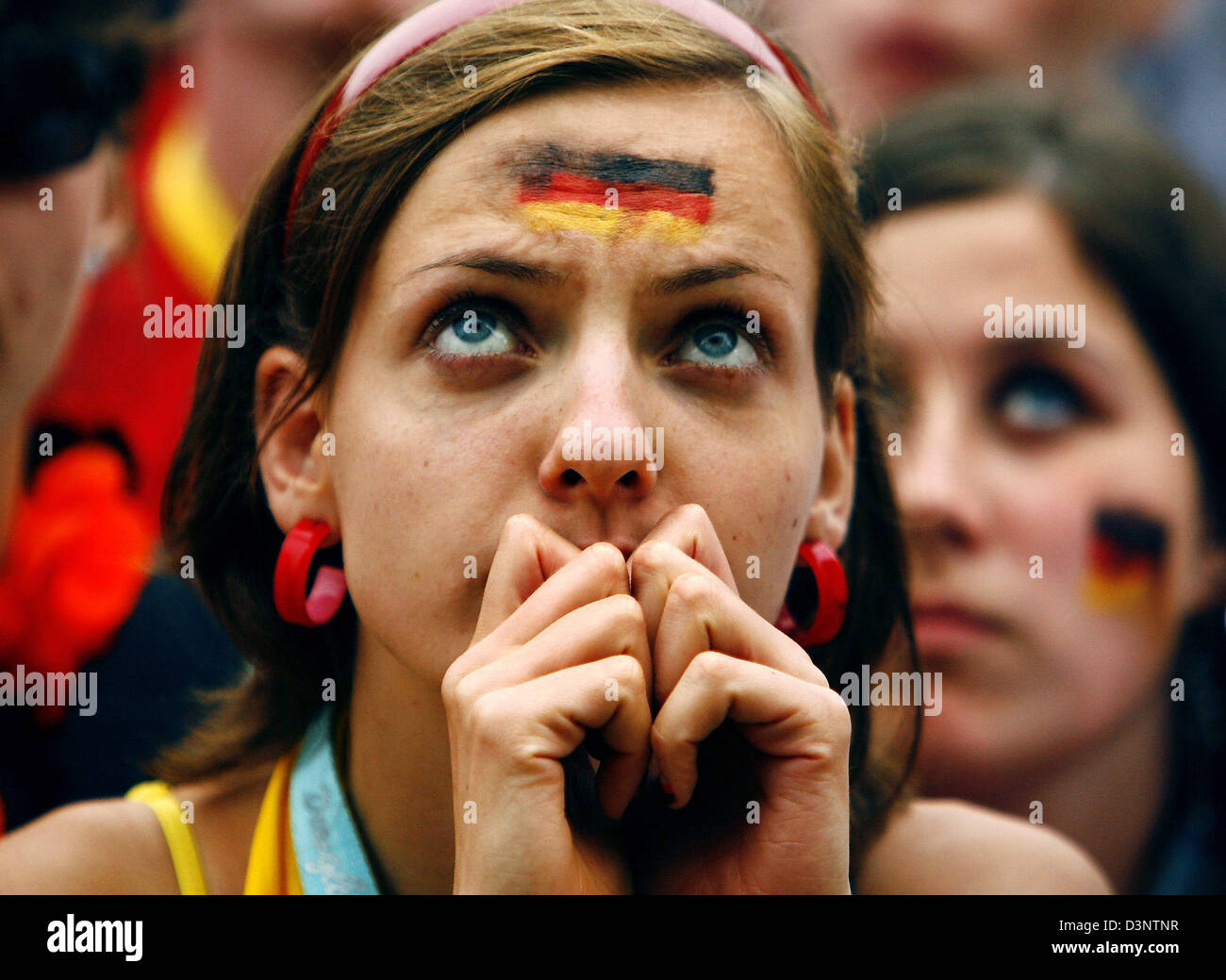 A female German soccer supporter holds thumbs at the FIFA fan festival ...
