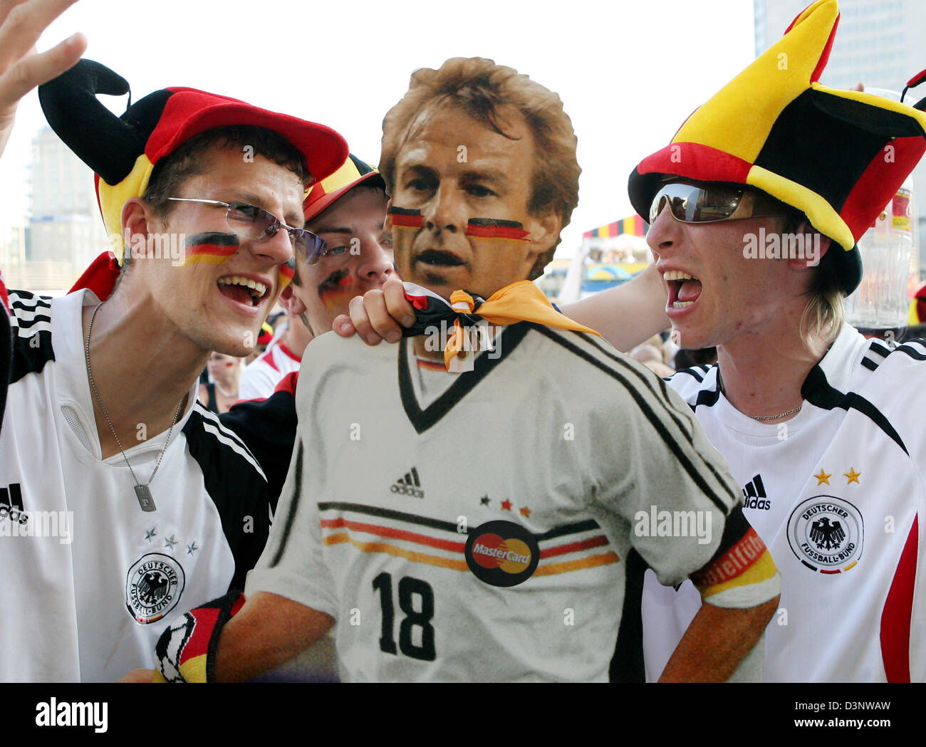 Confident German fans celebrate with a paperboard Klinsmann at the Fan ...