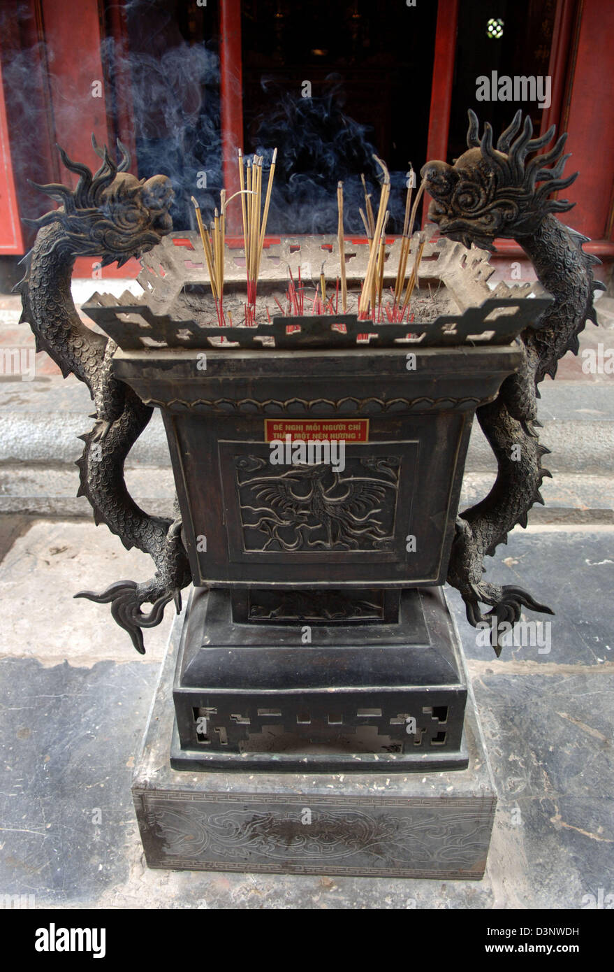 Joss stick placed in a sand-filled cask which is decorated with two ...