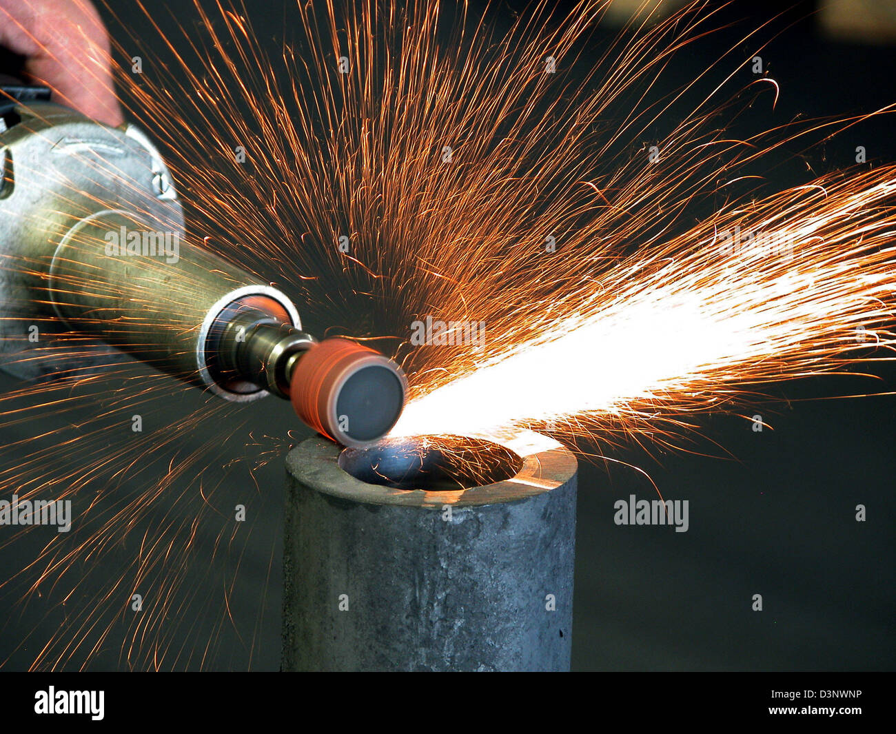 (dpa file) - A grinder causes flying sparks while grinding a metal tube ...