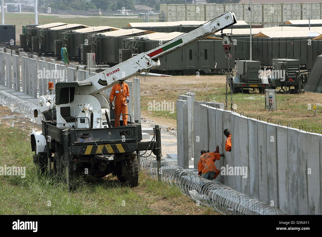 Local workers build a concrete wall at the EU military camp in Kinshasa ...