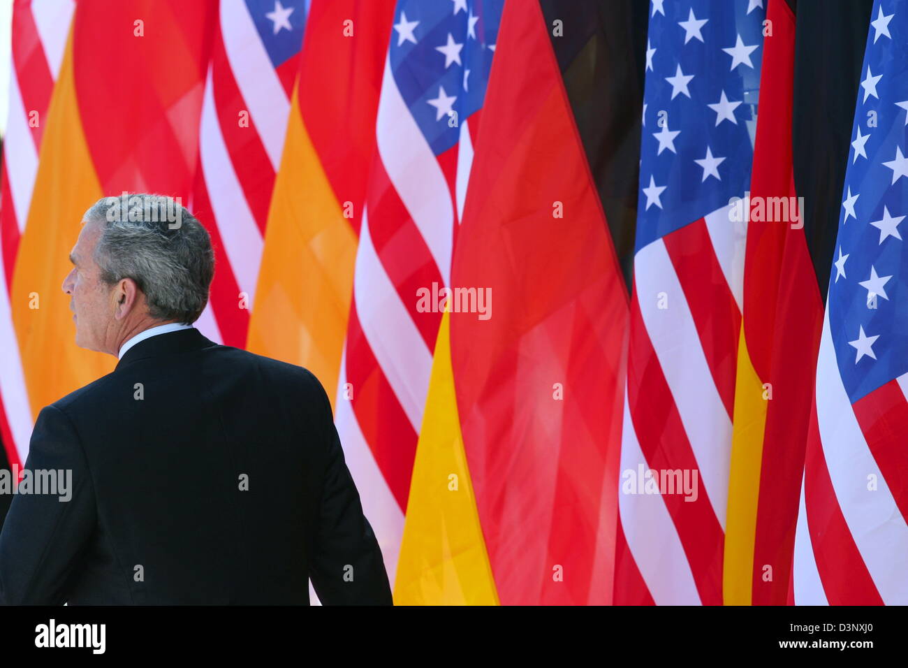 US President George W. Bush walks past flags on a tribune on the market ...