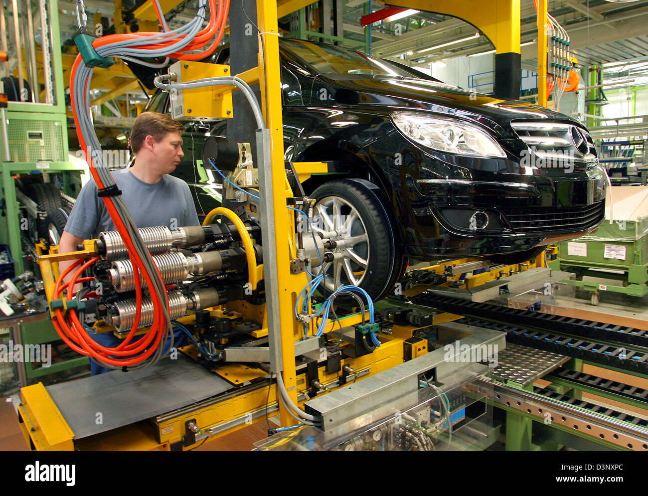 An employee of DaimlerChrysler mounts the wheels to a Mercedes Benz B ...