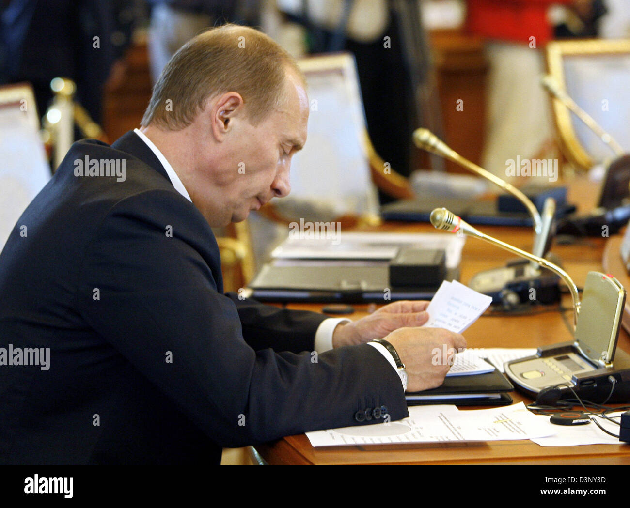 Russian President Vladimir Putin reads his documents at the Marble Hall ...