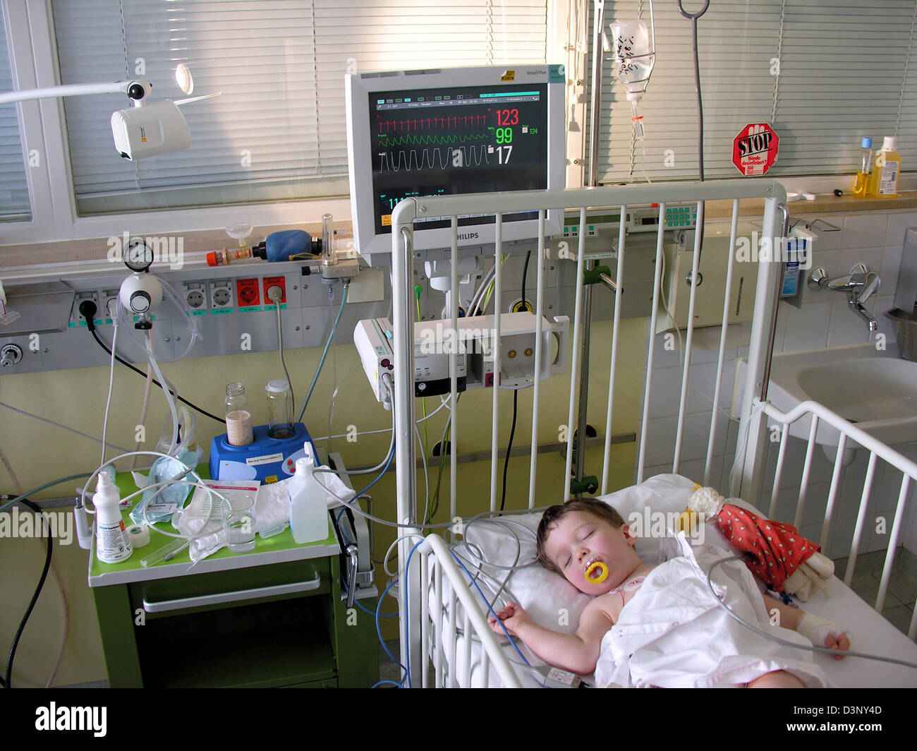 A two-year old boy lies in a cot in intensive care at a hospital in ...