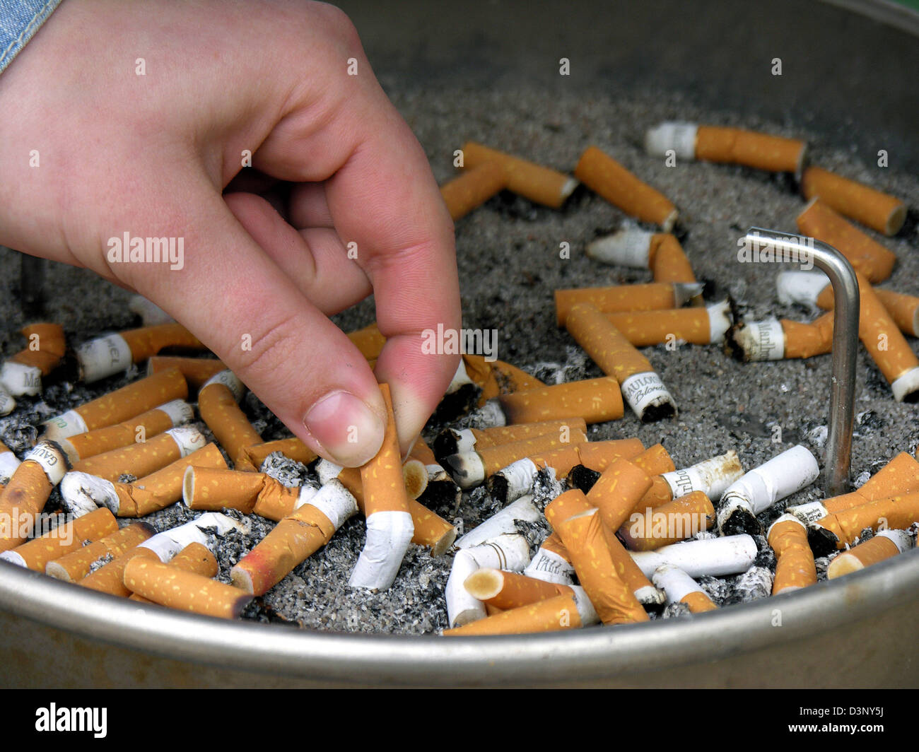 A smoker stubs out his cigarette in an ashtray in Esslingen, Germany, 1 ...