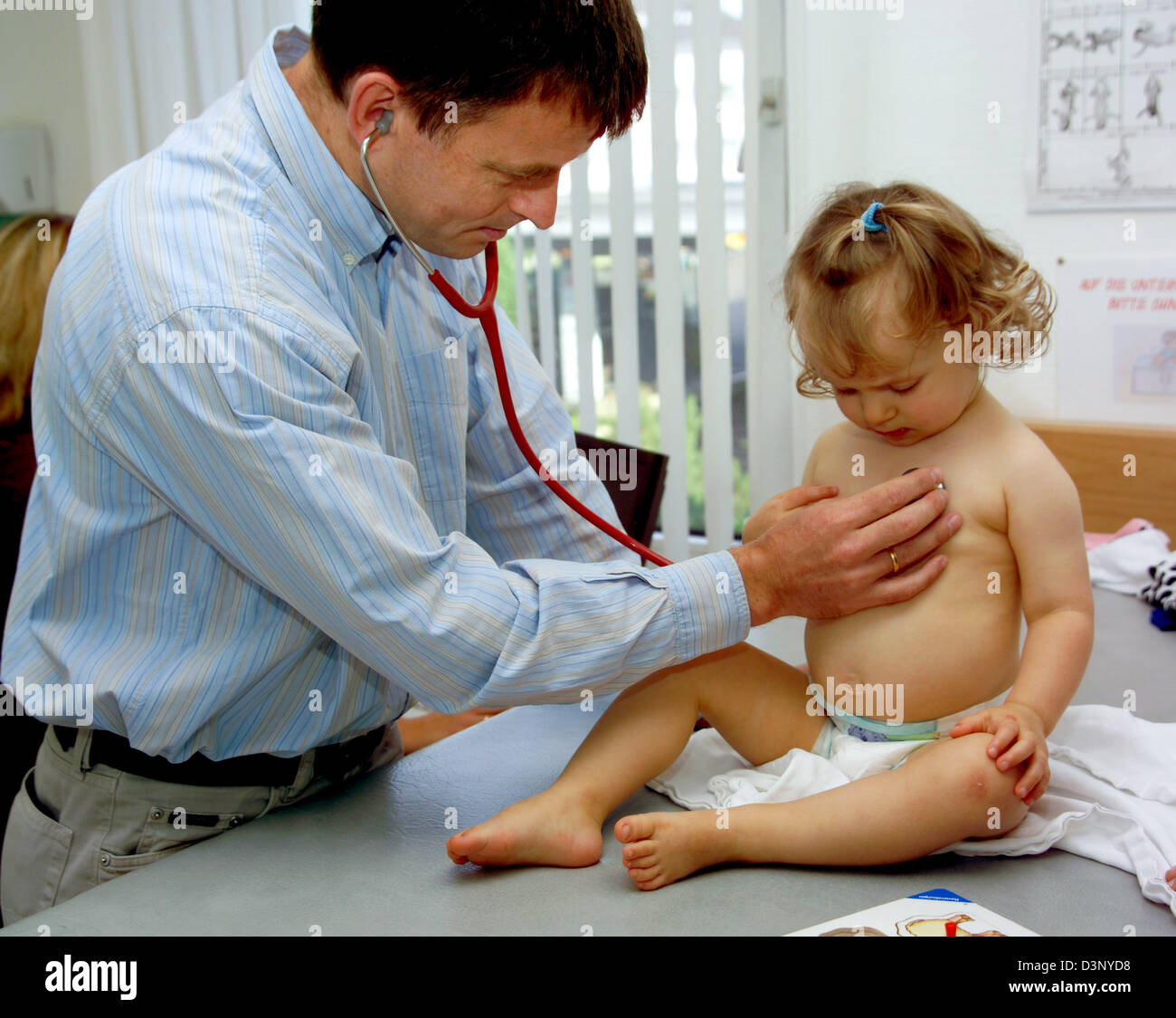 (dpa file) - A little girl sits on the examination table while the ...