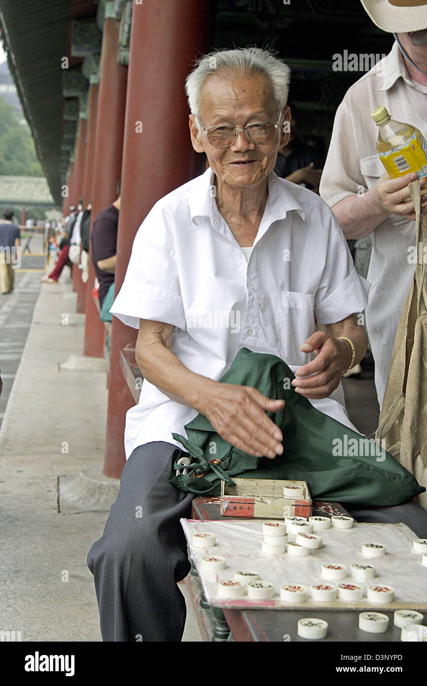 An elderly man plays a typical Chinese board game in a park in Beijing ...