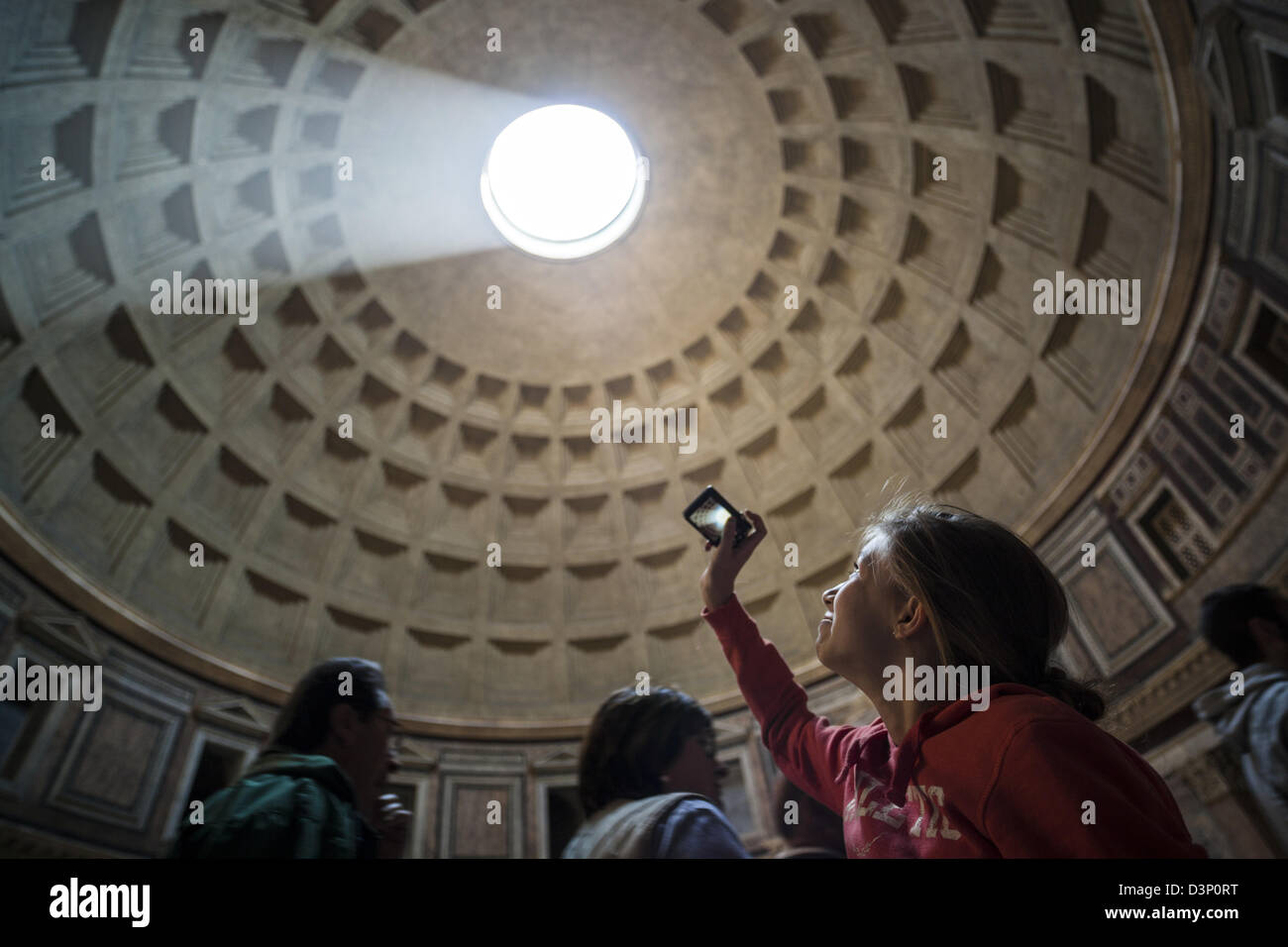 Young girl looking at and taking photos of the sunlight coming through ...