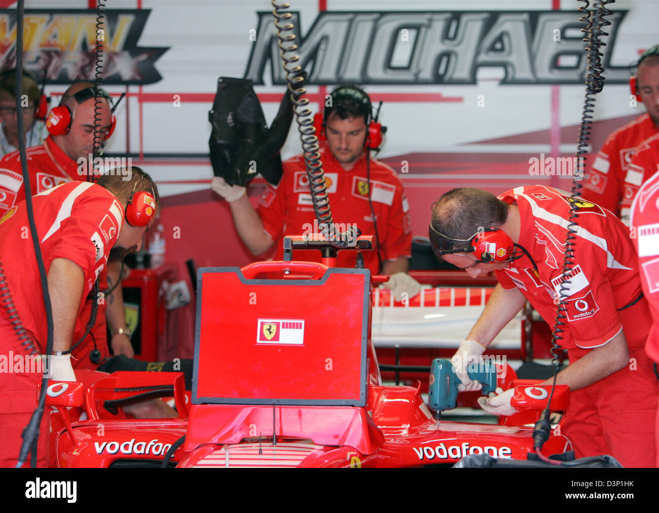 Mechanics of the Ferrari Formula One team work on Michael Schumacher's ...