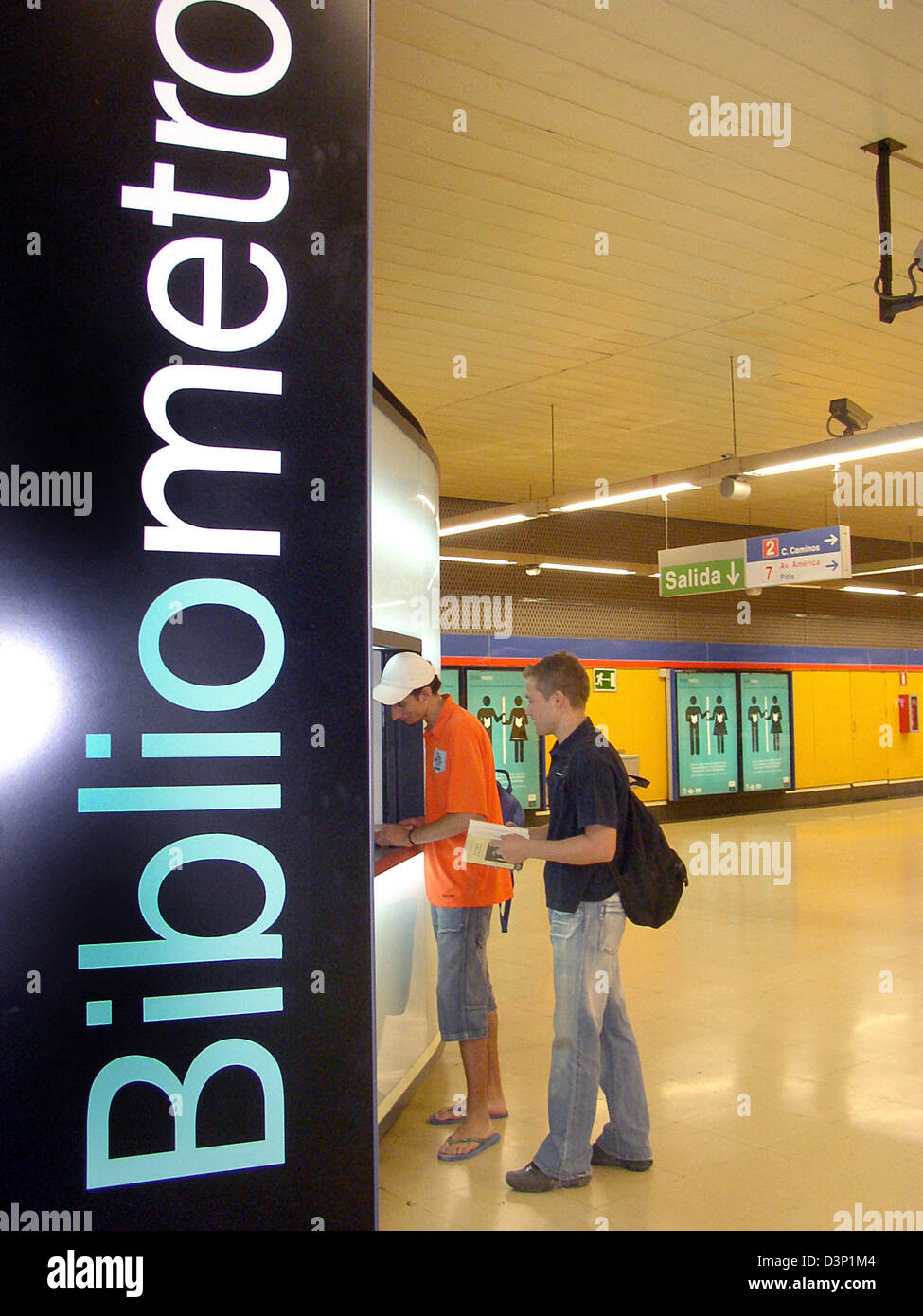 Two customers visit a Bibliometro mini-library stand at a subway ...