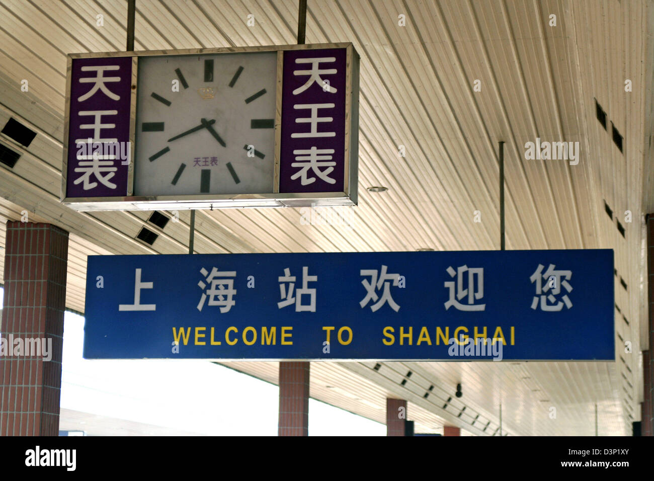 The picture shows a hanging clock and a 'Welcome to Shanghai' sign at ...