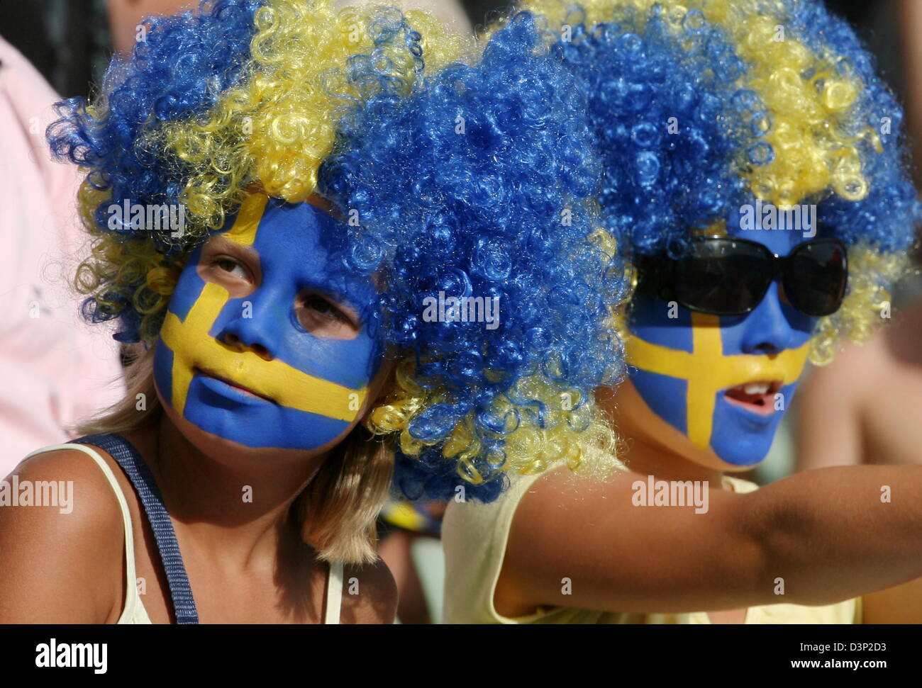 Swedish fans are pictured with painted faces and wearing wigs on the ...