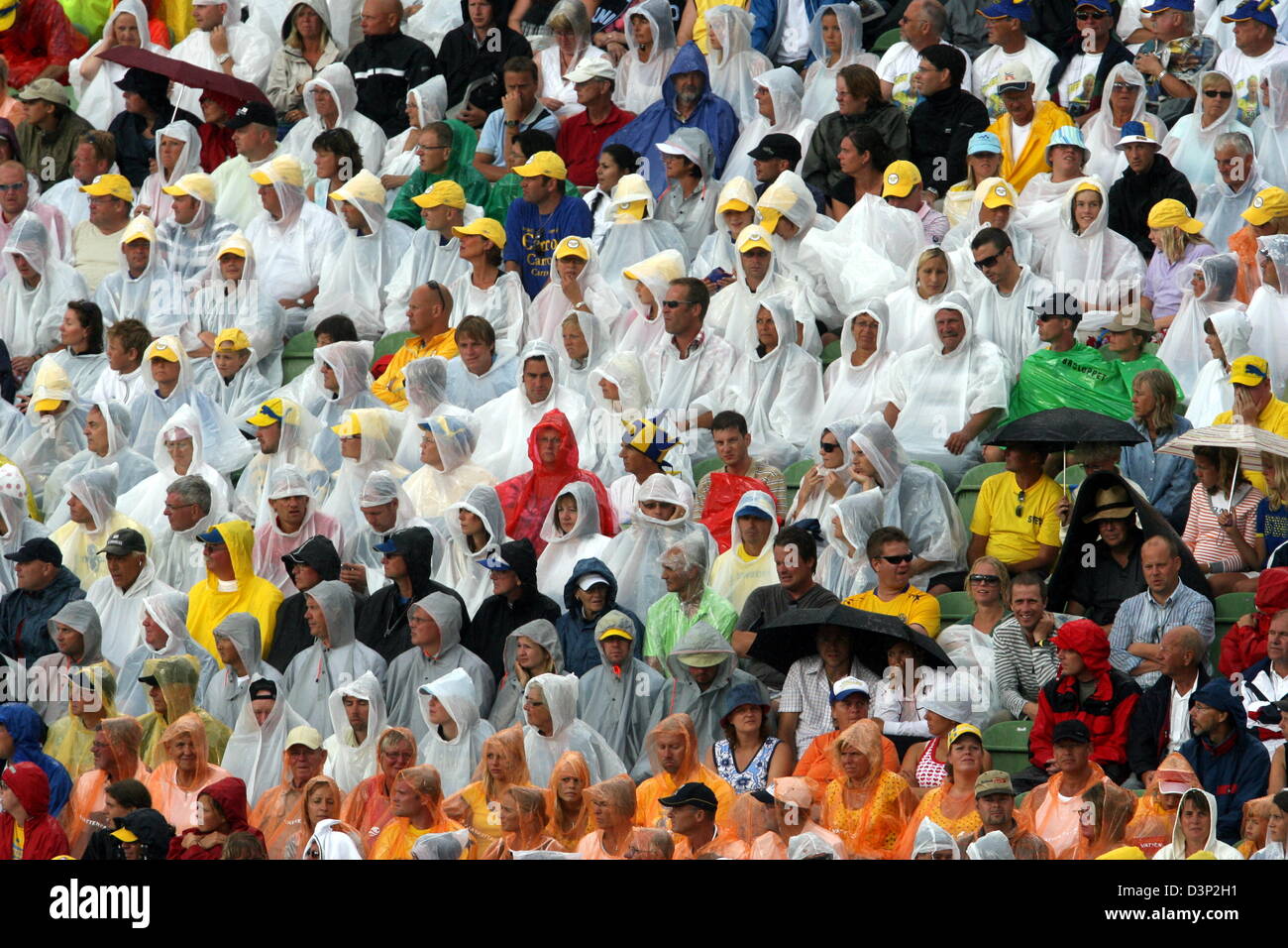 Visitors follow the competitions in rain coats during a rainy spell at ...