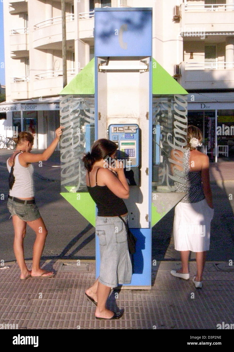 Women talk on public phones by telecommunication company telefonica in ...