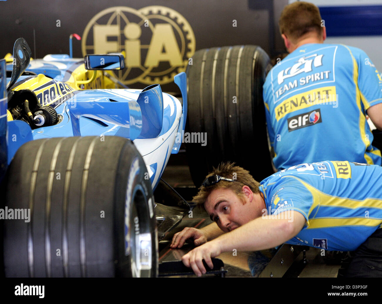 Mechanics of Renault F1 Racing work on the race car in the FIA garage ...