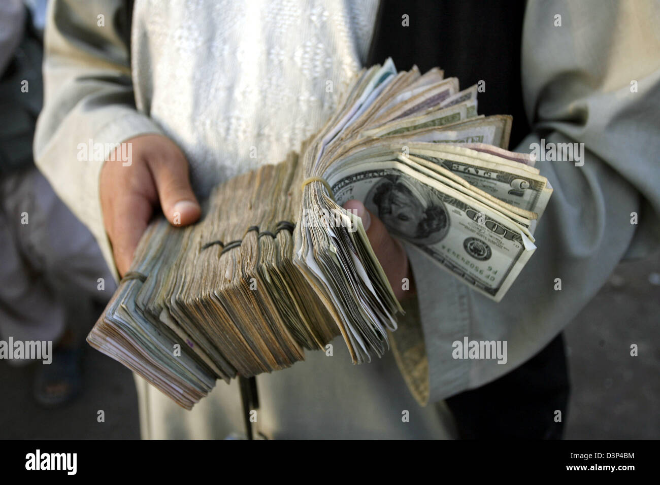 A money changer holds various banknotes, among them also US-American ...
