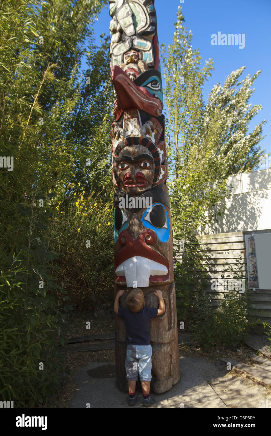 Boy (4-5) looking at totem pole Stock Photo - Alamy