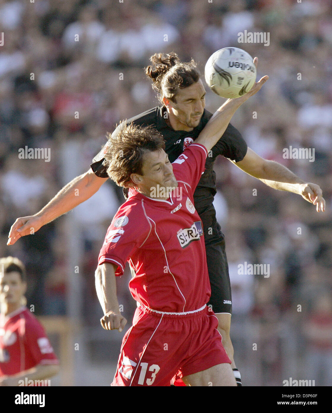 Alexander Blessin (bottom) of Siegen uses his hand to win the heading ...