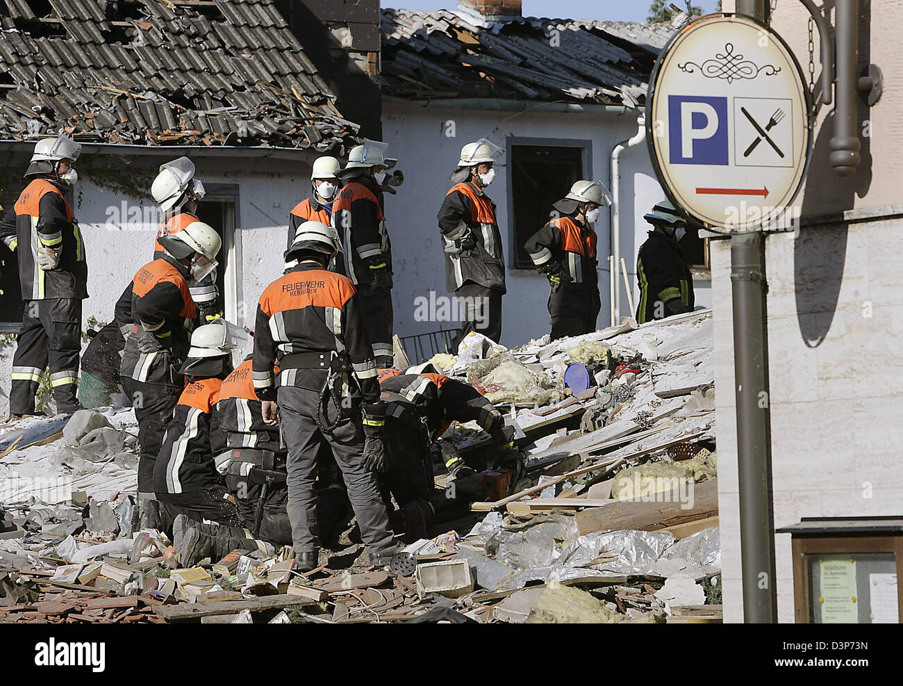 Firemen shown during clean-up and salvage operations at two house ruins ...