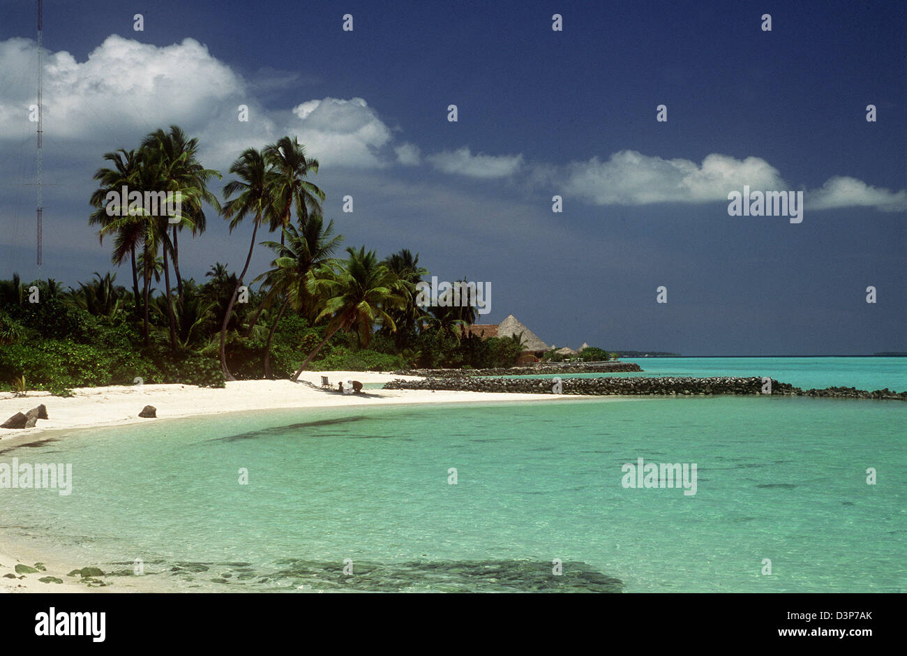 The picture shows a tourist couple in deck chairs on Ari Beach ...