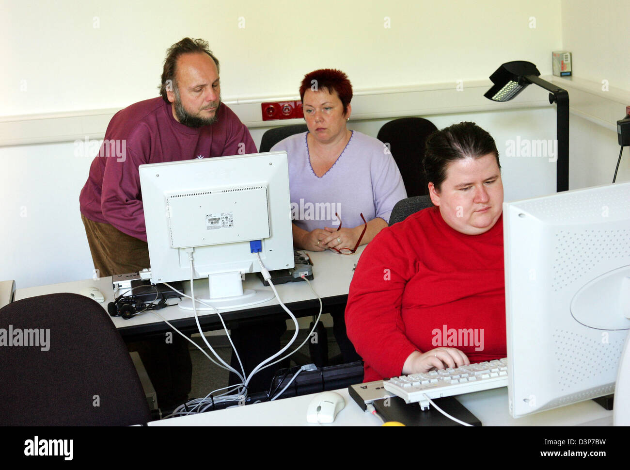 A blind teacher (L) teaches his blind students computer skills in a ...