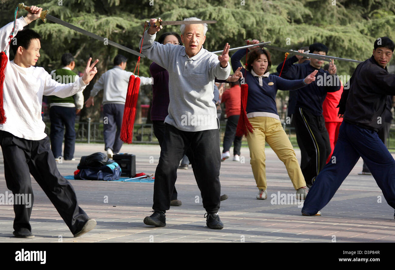 Old and young Chinese perfom the traditional shadow boxing, Tai Chi, at ...