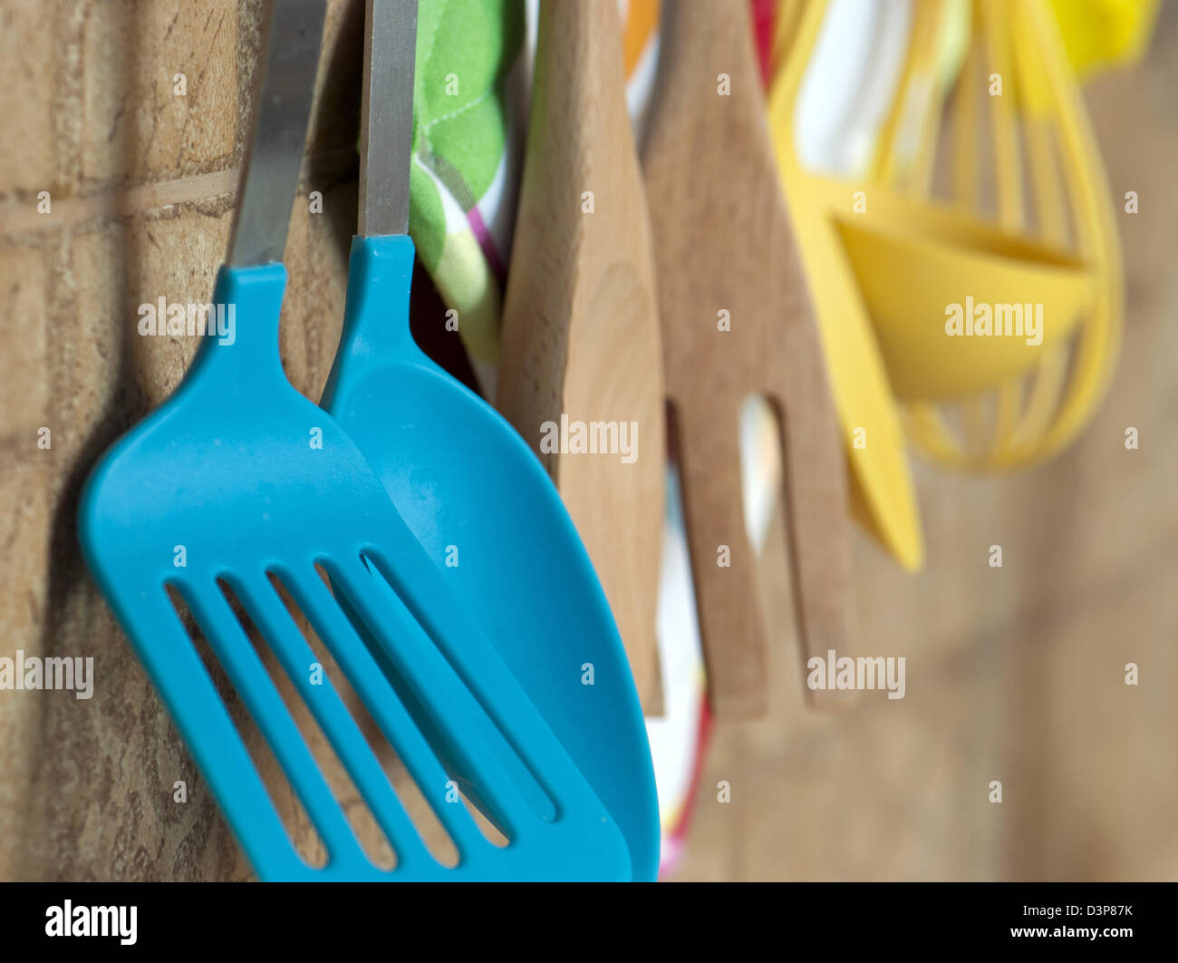 Set of kitchen tools hanging on the stone wall Stock Photo - Alamy