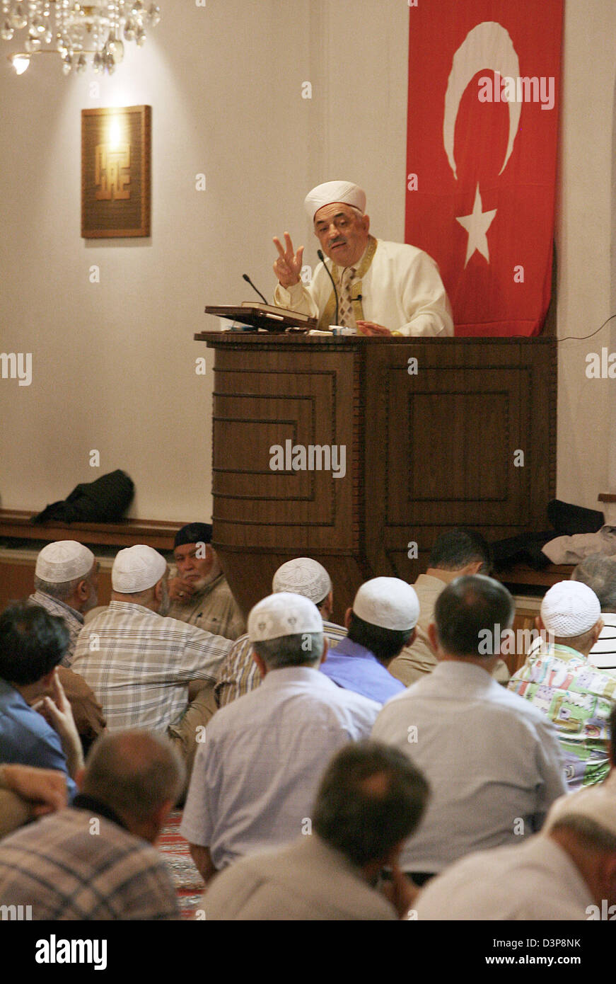 An imam speaks to Turkish muslims prior to the Friday prayer during the ...