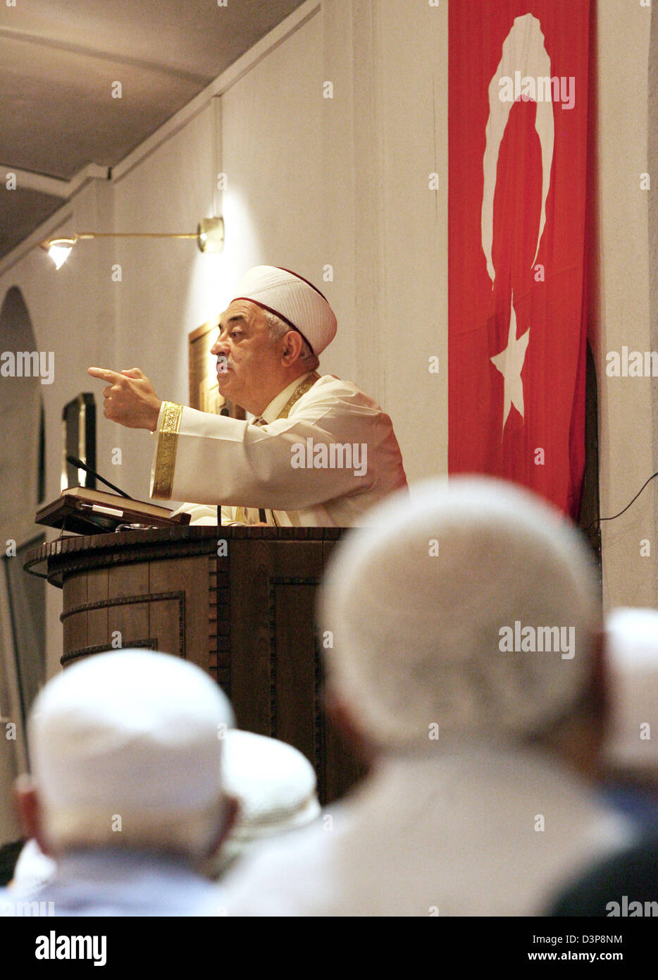 An imam speaks to Turkish muslims prior to the Friday prayer during the ...