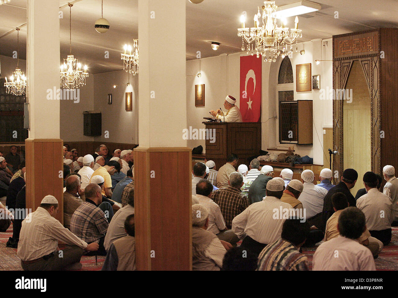 An imam speaks to Turkish muslims prior to the Friday prayer during the ...