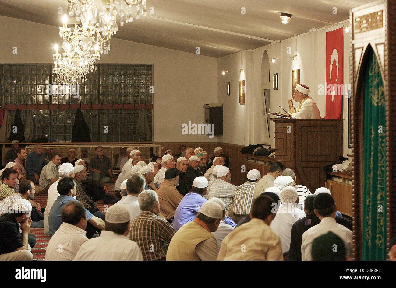 An imam speaks to Turkish muslims prior to the Friday prayer during the ...