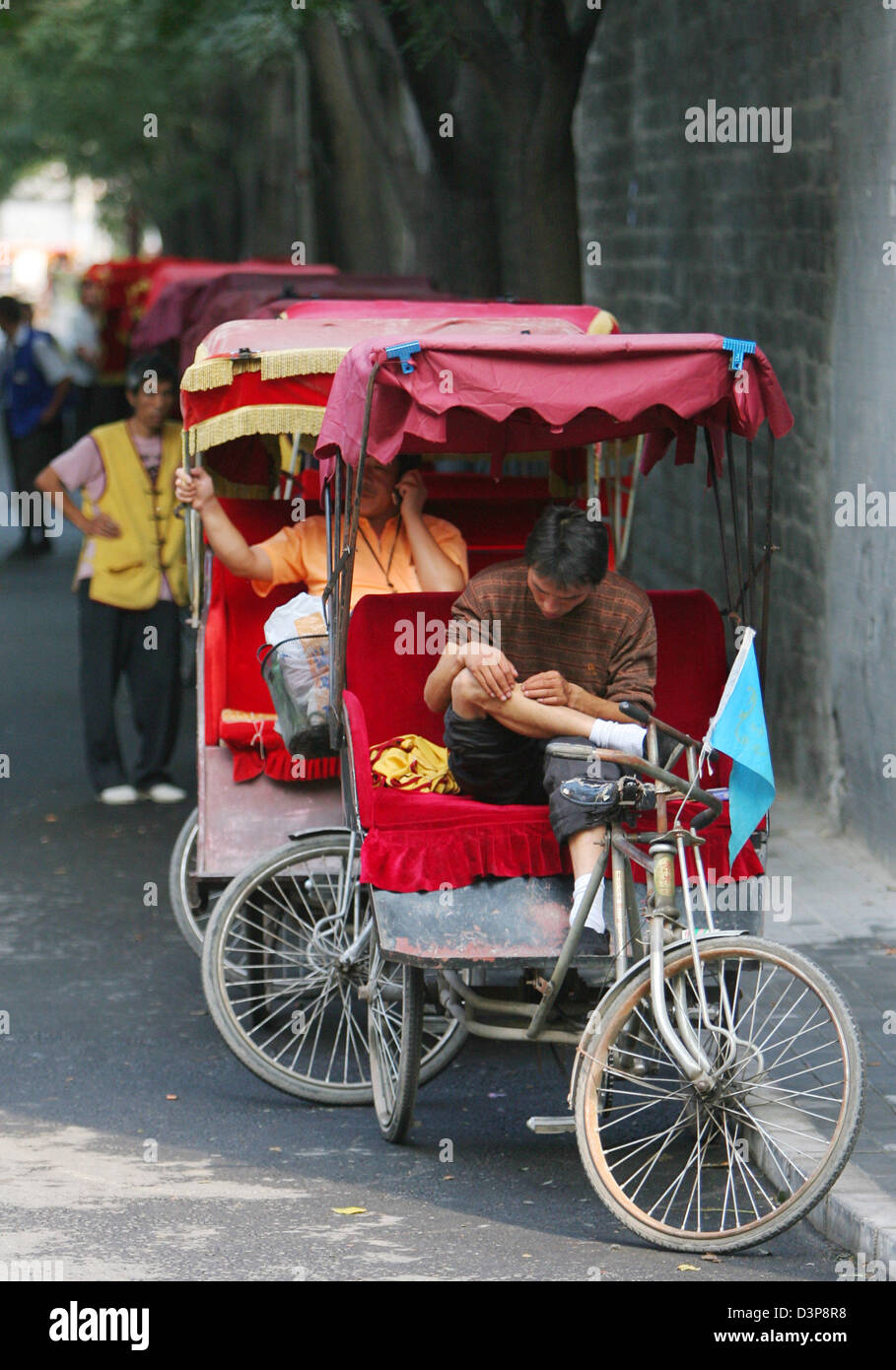 Rickshaws drivers wait for customers in a traditional residential ...