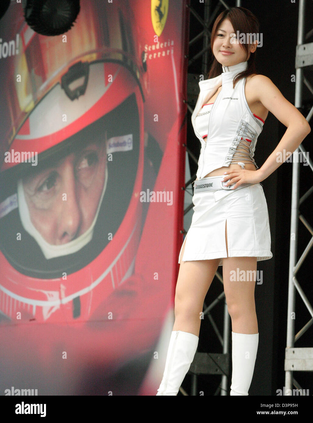 A hostess stands on a stage next to a picture of the German Formula One ...