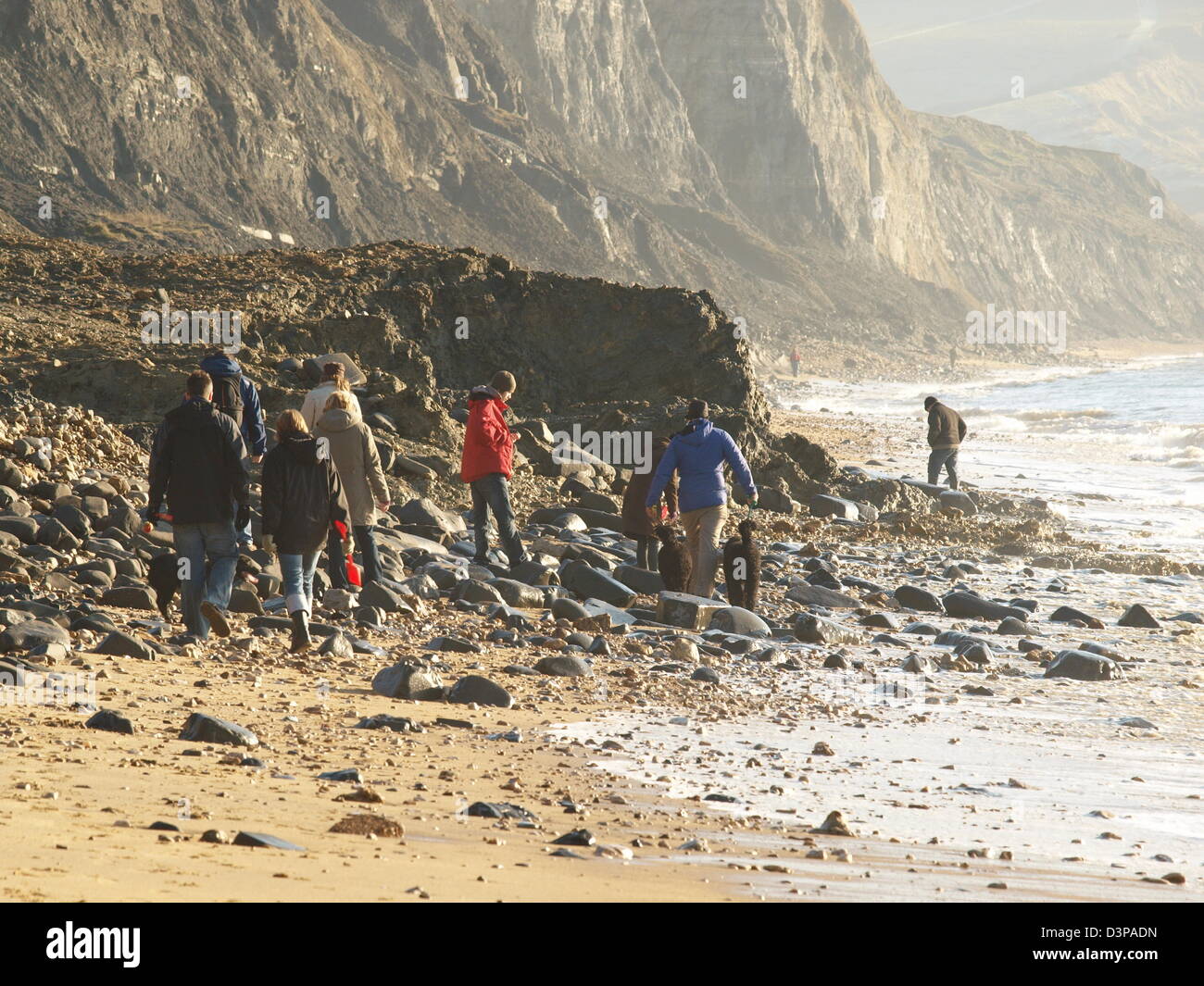 Fossil hunters scramble over rocks on Charmouth beach Stock Photo - Alamy