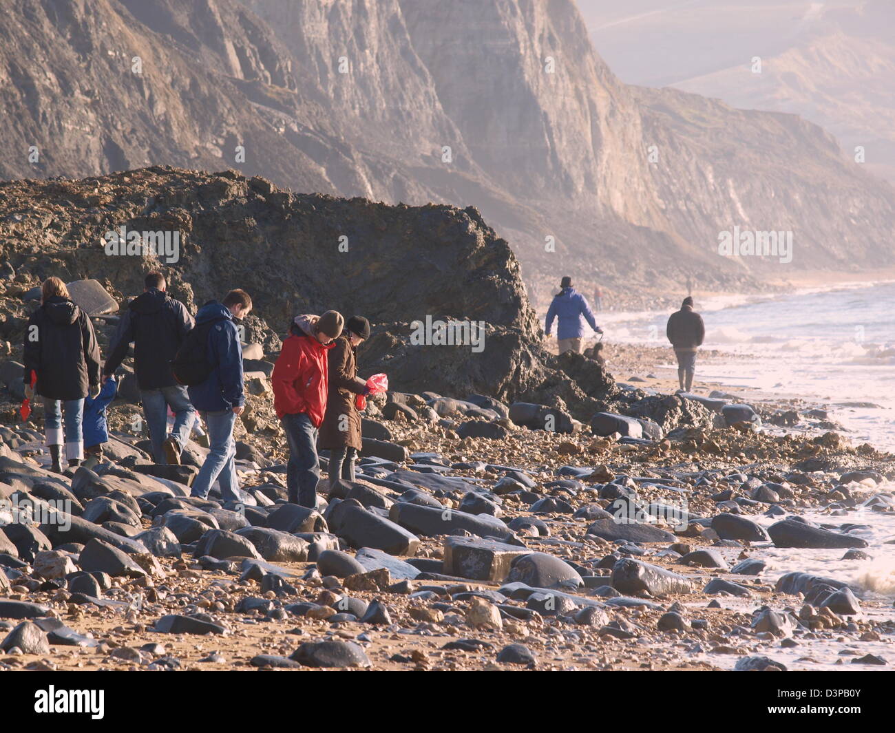 Fossil hunters scramble over rocks on Charmouth beach Stock Photo - Alamy