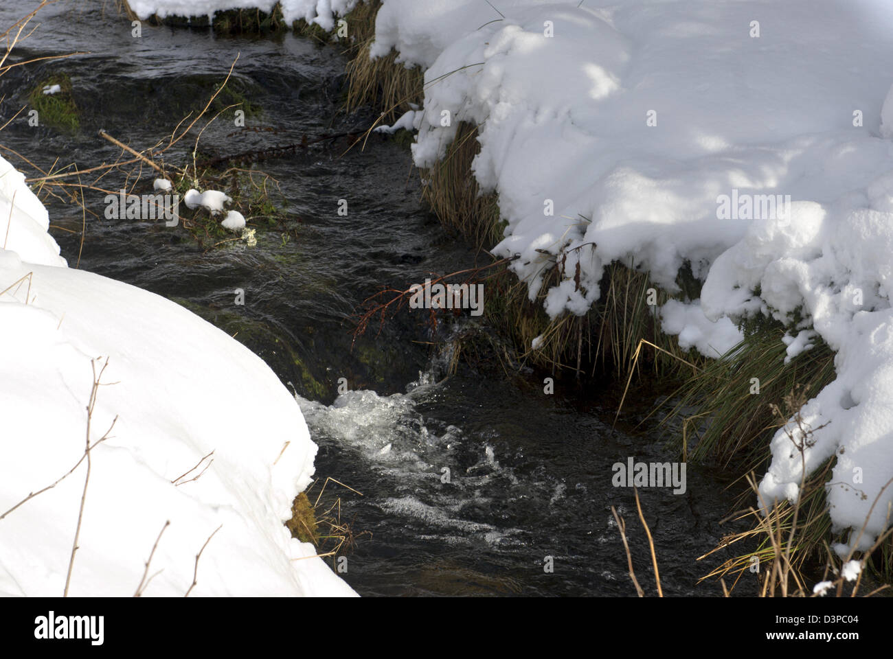 Stream flowing through snow covered hi-res stock photography and images ...