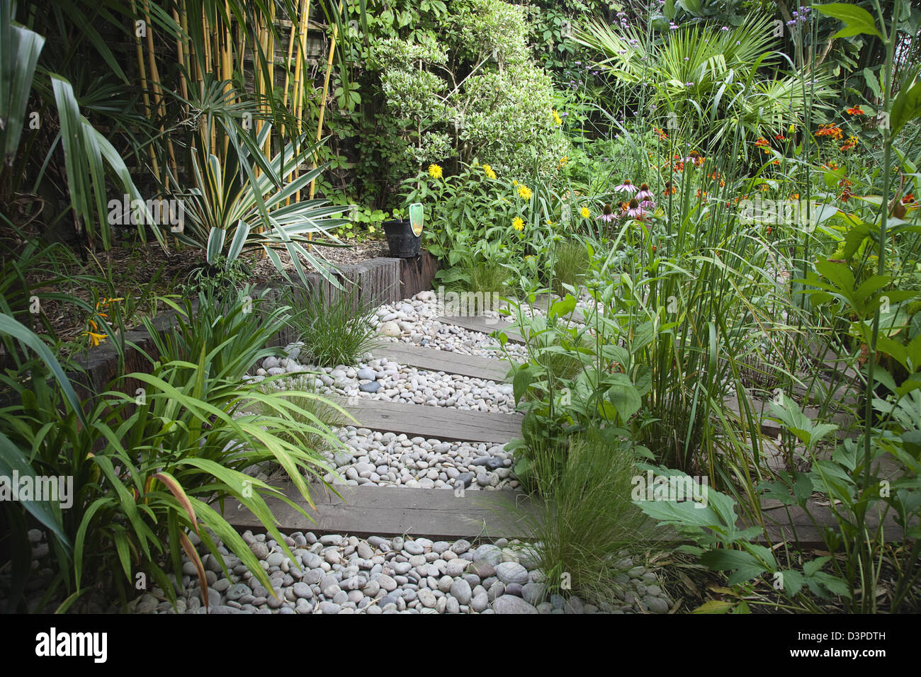 Urban garden with pebble path and railway sleepers Stock Photo - Alamy