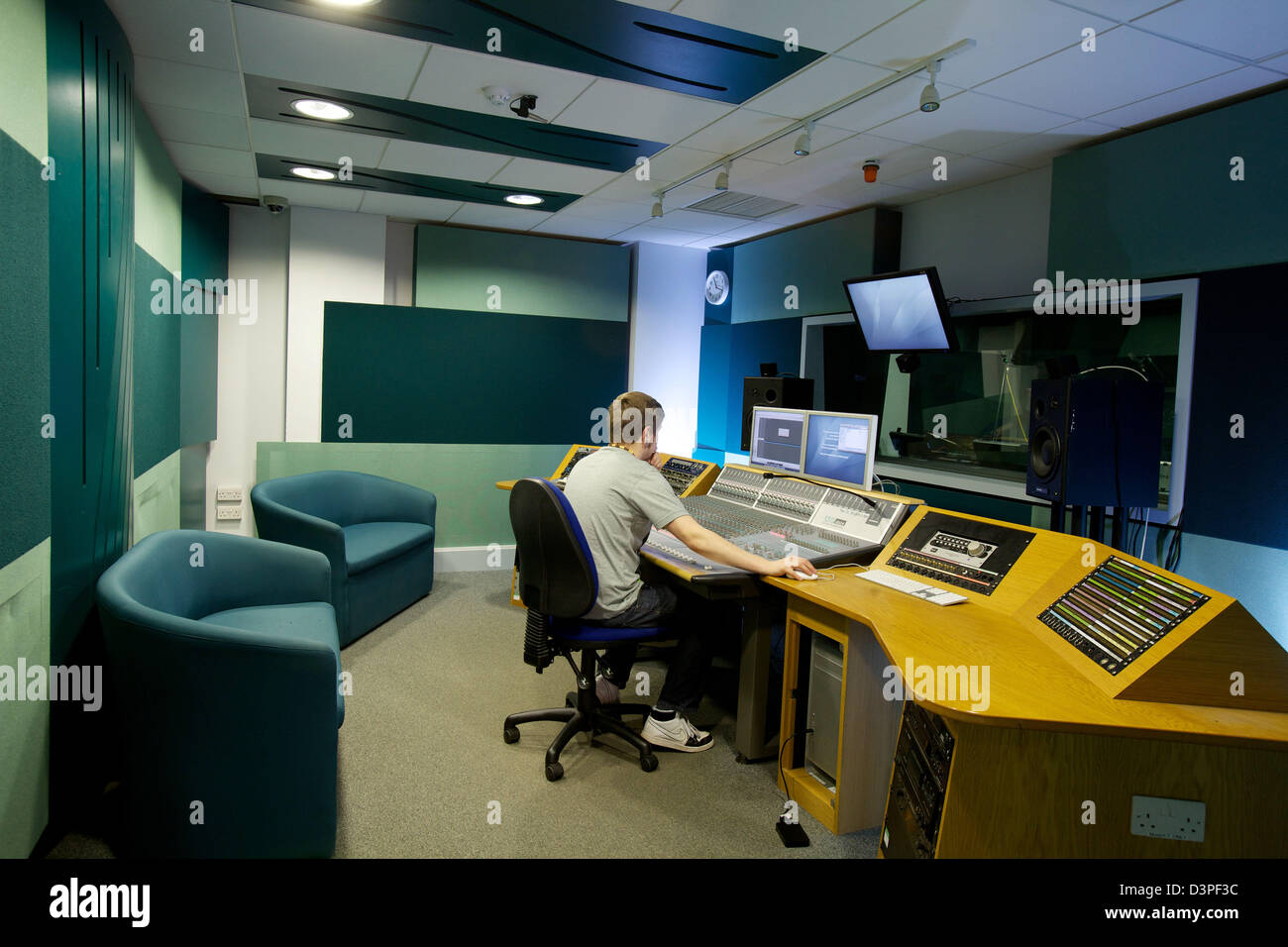 Students working in music studio on mixing desk with computers hi-res ...