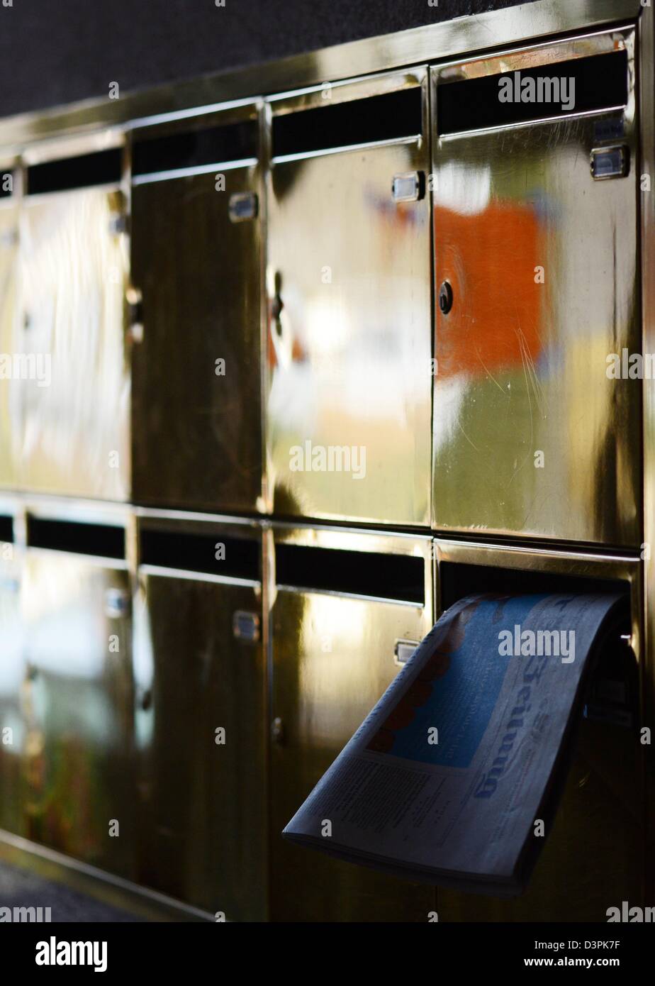 A newspaper sticks out of a letter boxes brass in a corridor in Berlin ...