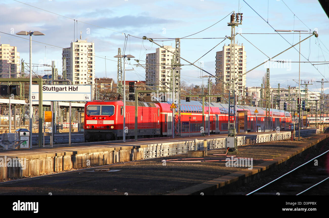 A red railway engine and train arriving at a platform at Stuttgart Hbf ...