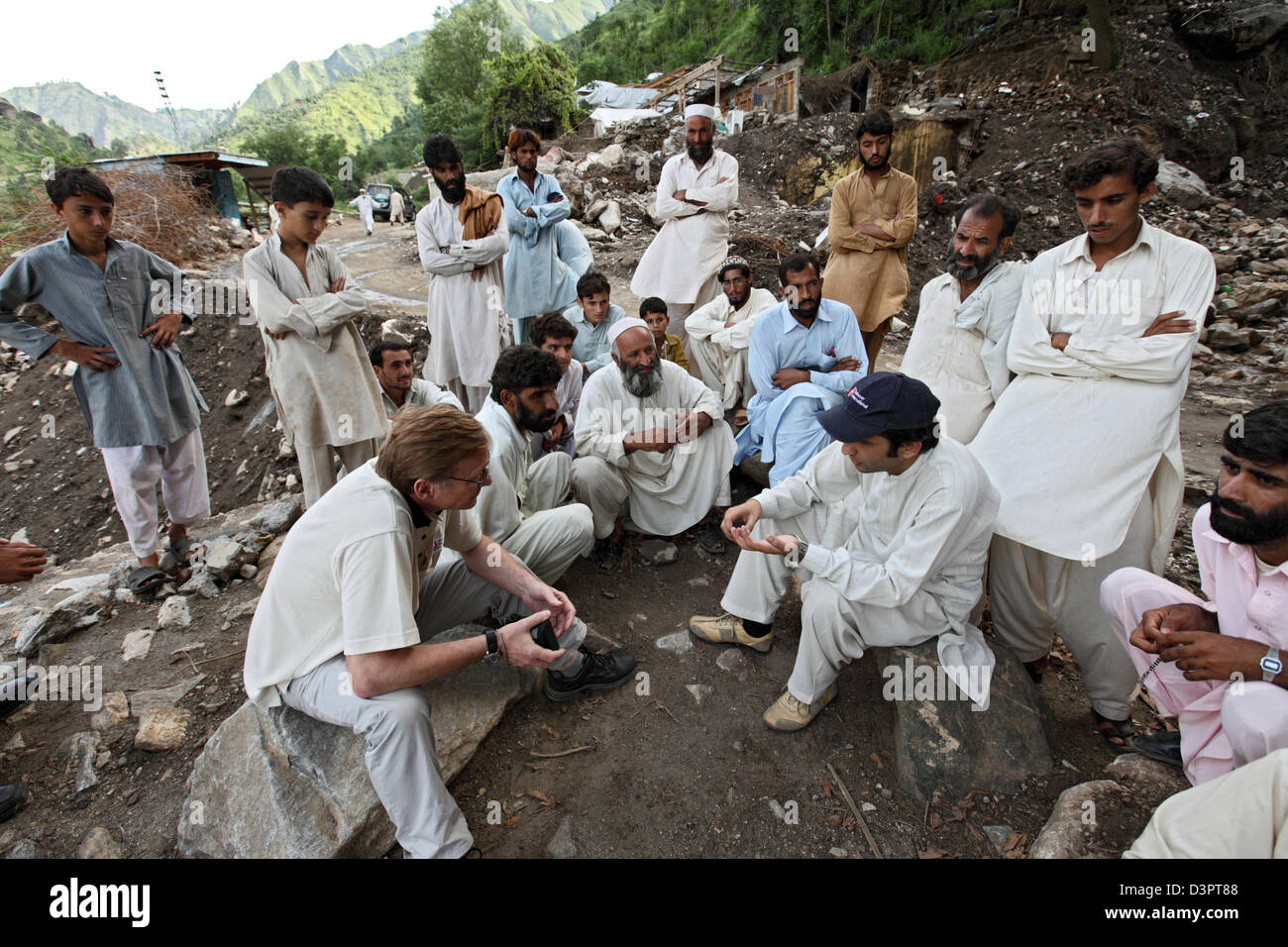 Kokarai, Pakistan, aid workers in discussion with residents Stock Photo ...