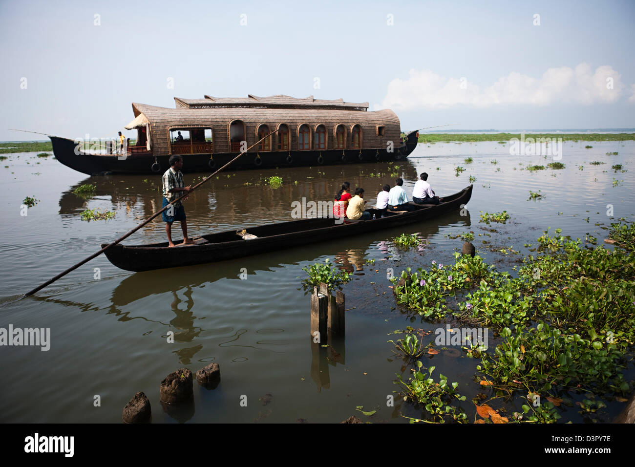 Tourists in a canoe near a houseboat, Kerala Backwaters, Alappuzha ...
