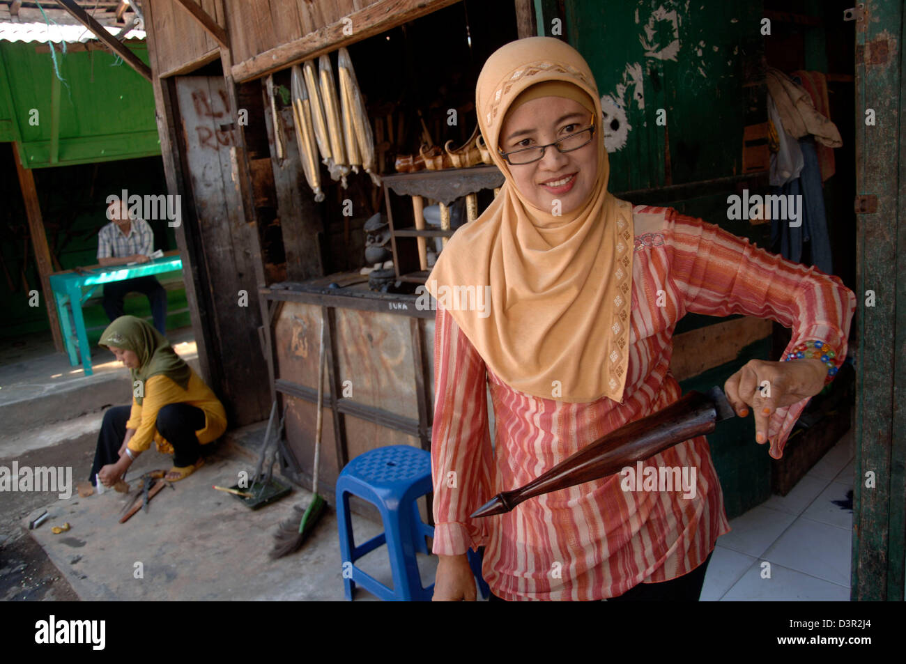 Female kris maker, Amah making kris sheaths in the kris market Setono ...